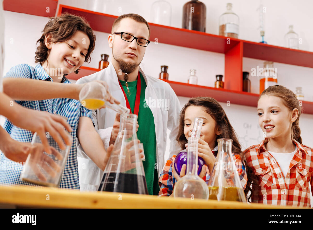 Science lovers. Positive delighted intelligent children standing around ...