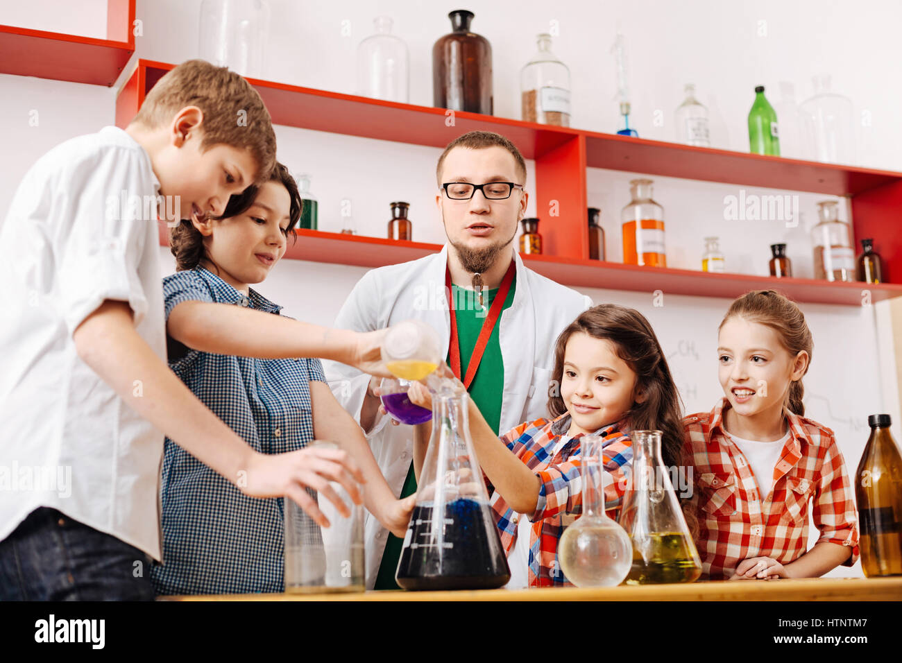 Controlling the experiment. Nice experienced male teacher standing in ...