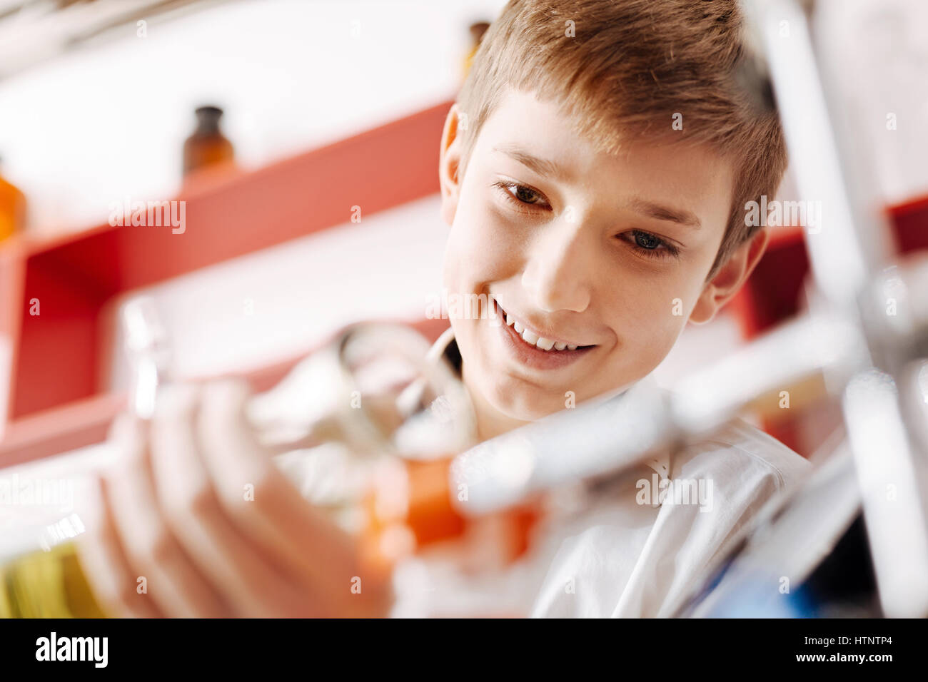 I like chemistry. Joyful smart delighted boy smiling and carrying out ...