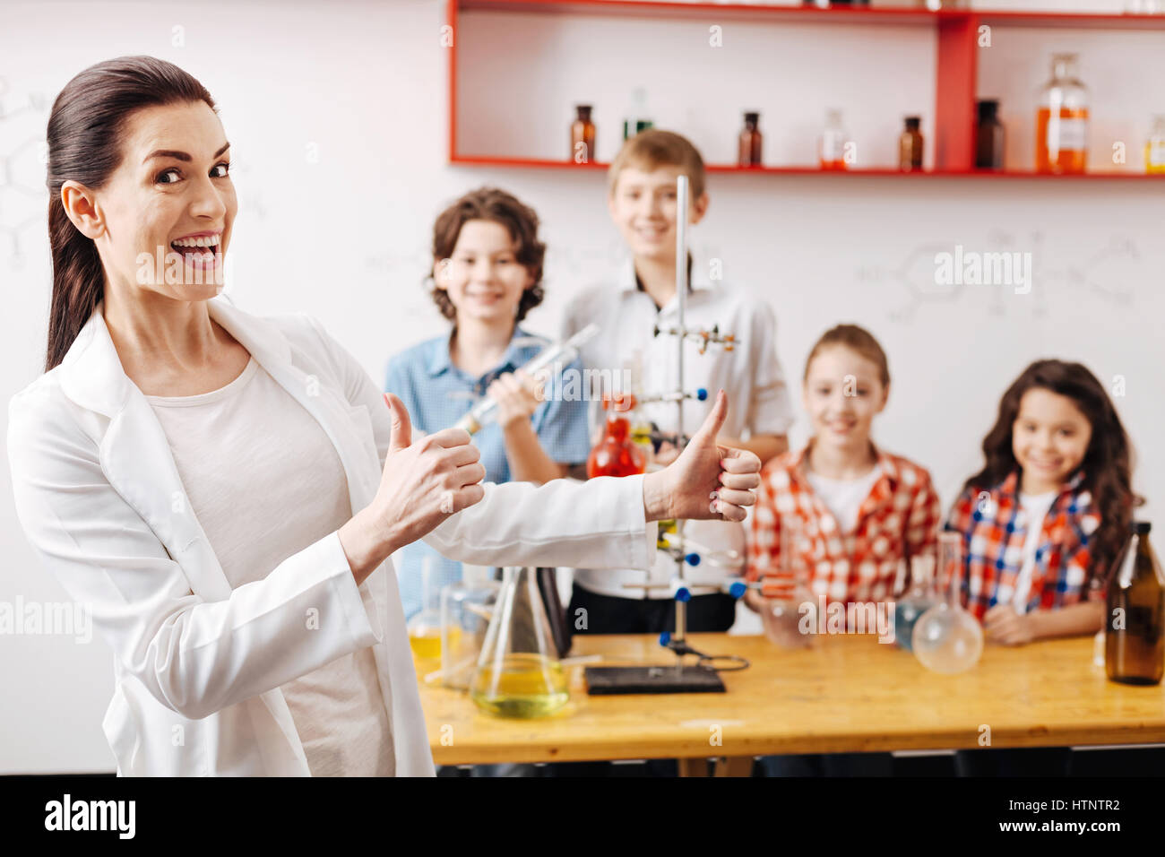 Good job. Happy delighted positive teacher standing in the classroom ...