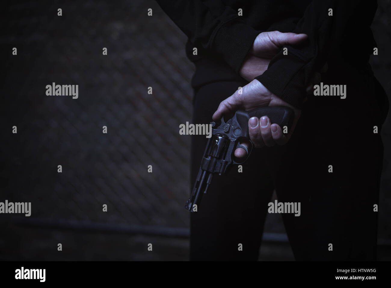 Ready to attack. Thoughtful patient dangerous criminal holding a gun in ...