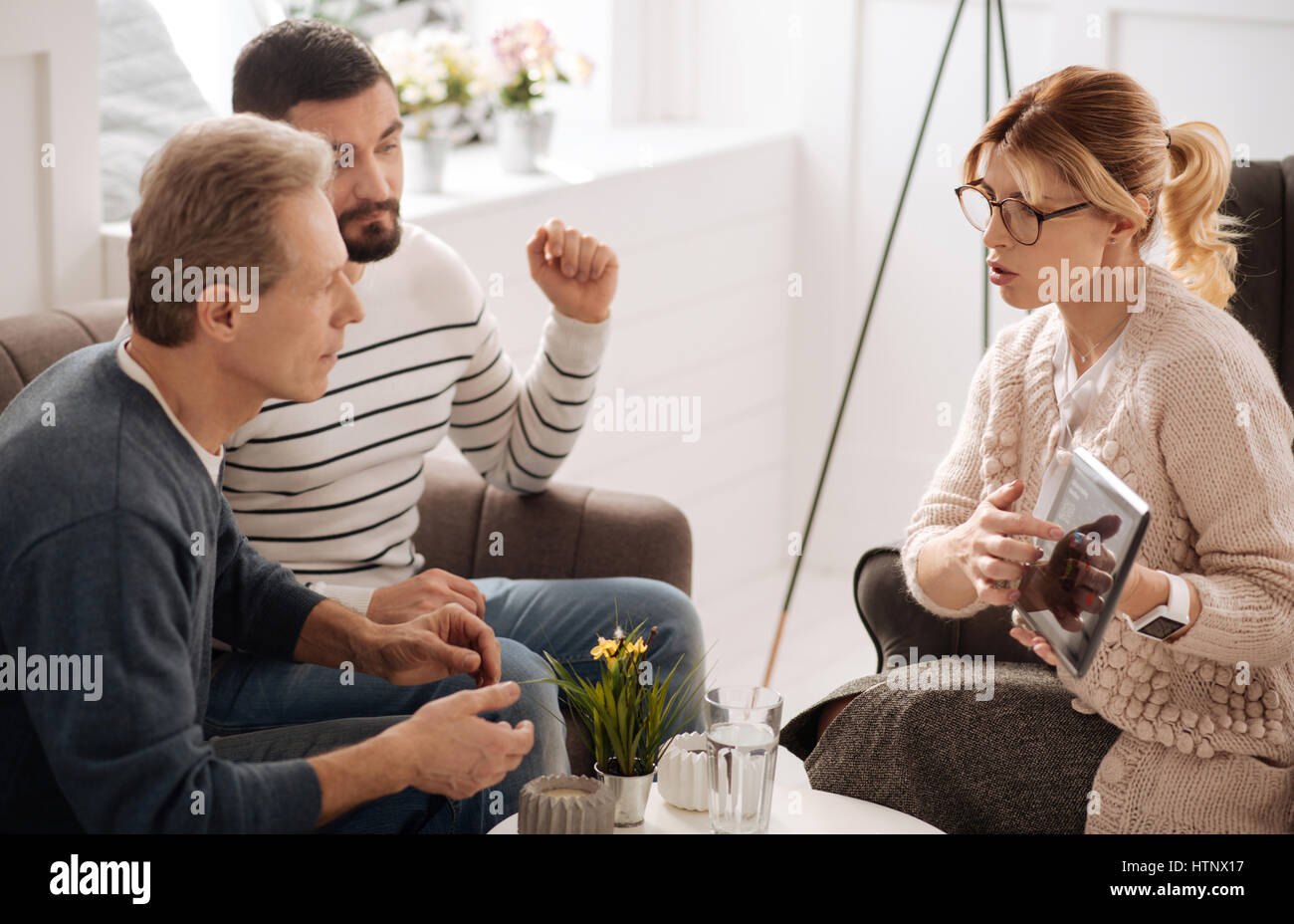 Part of the therapy. Serious nice attractive therapist using a tablet ...