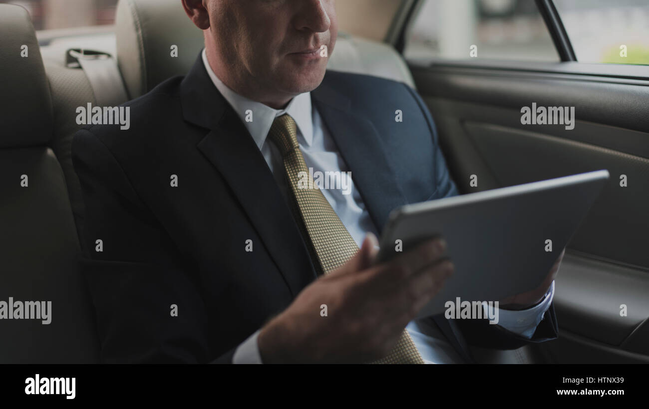 Businessman Using Tablet Working Car Inside Stock Photo - Alamy