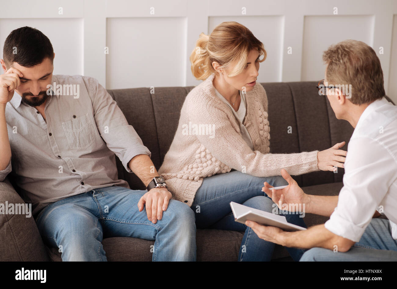 Family problems. Unhappy sad distressed couple sitting on the sofa and ...