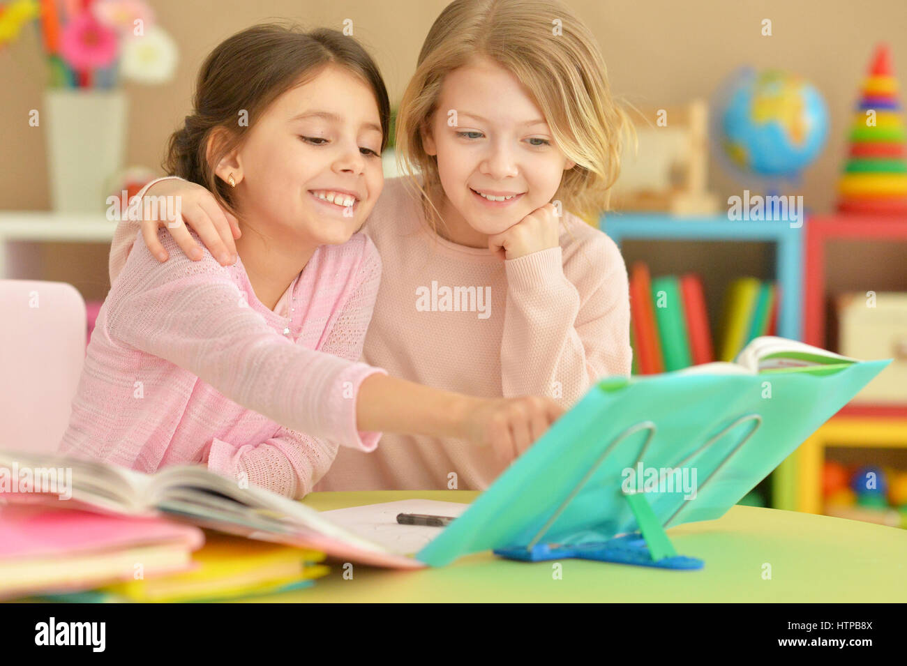 Portrait of two girls with their homework Stock Photo - Alamy