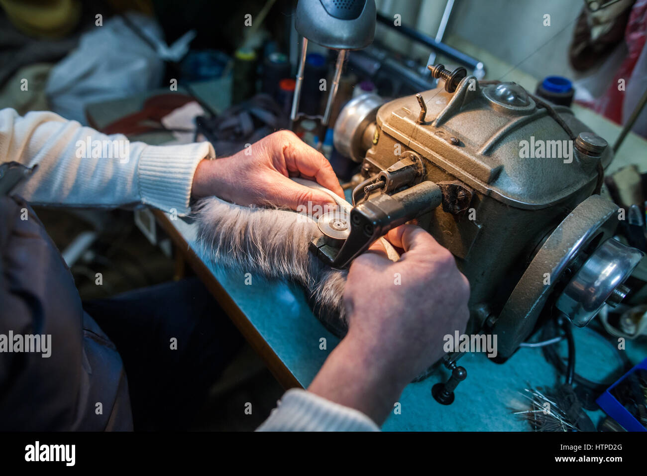Color image of a tailor using a fur sewing machine Stock Photo - Alamy