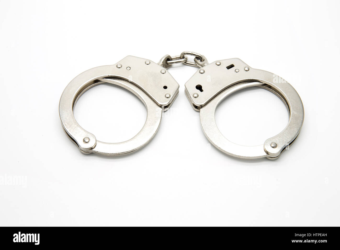 Handcuffs on white isolated background Stock Photo - Alamy