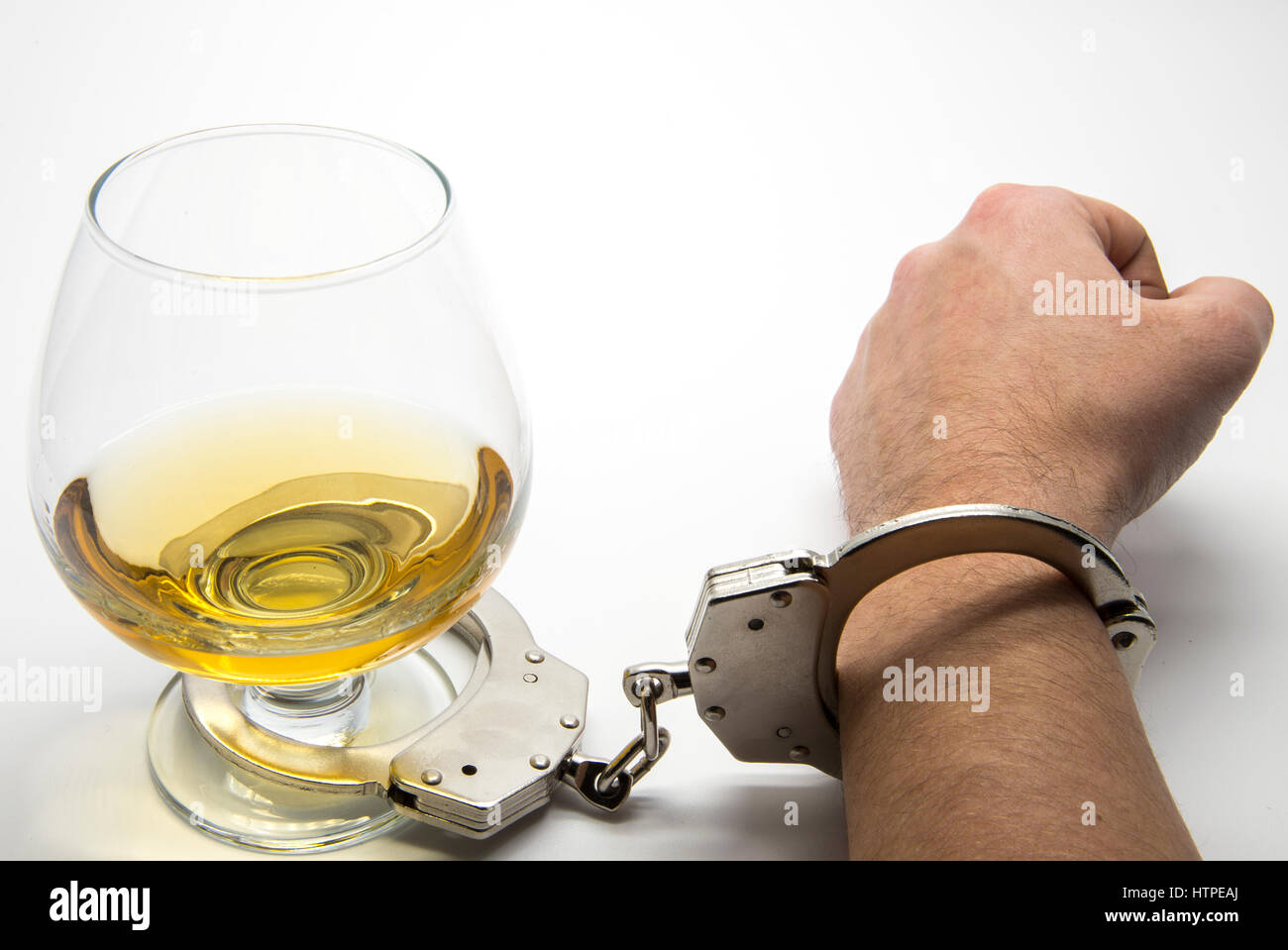 Alcohol and handcuffs - alcohol addiction concept Stock Photo - Alamy