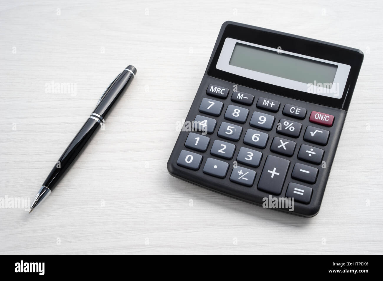 Calculator and pen closeup, wooden table Stock Photo - Alamy