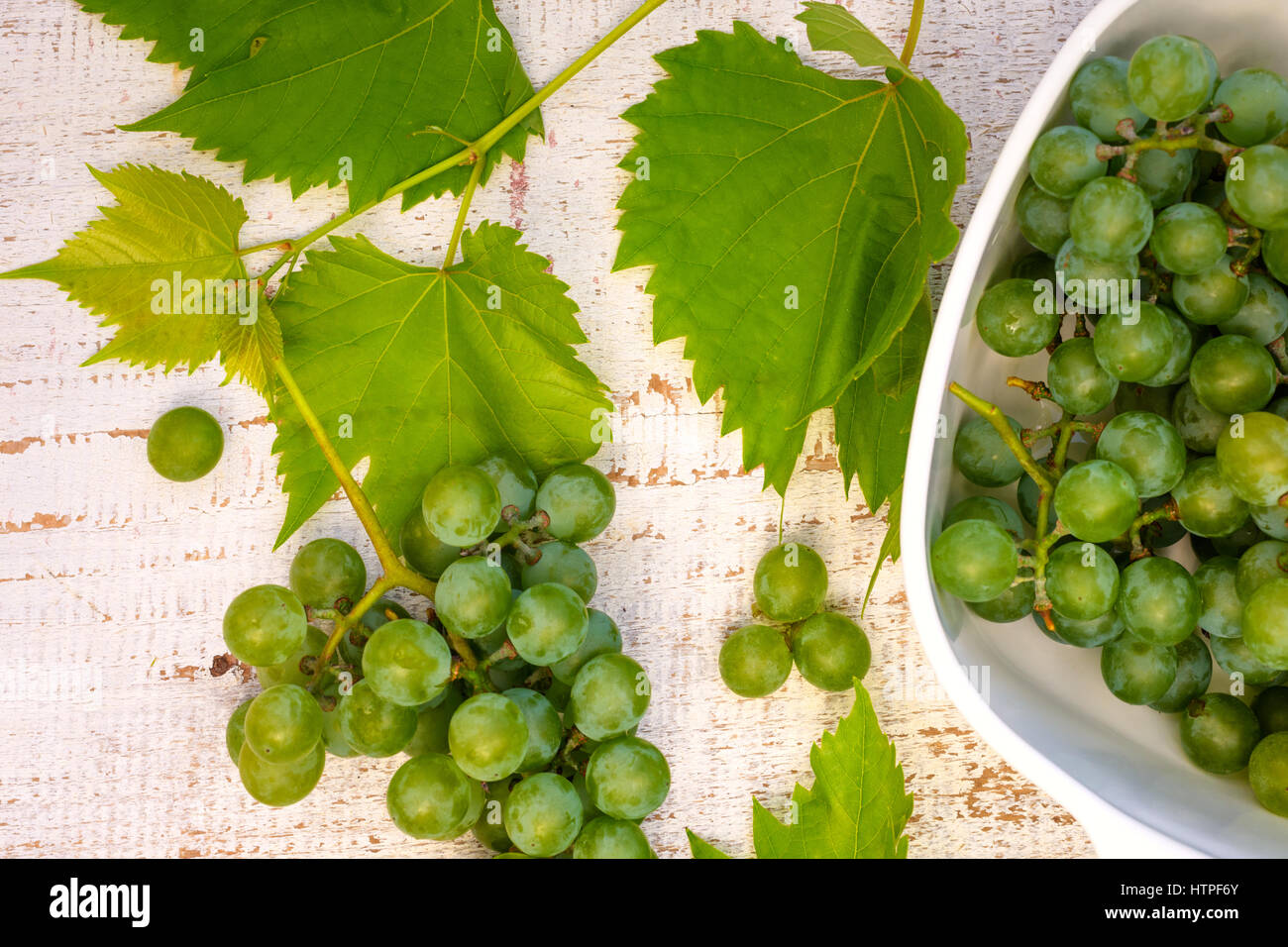 Grapes on white wooden vintage table Stock Photo - Alamy