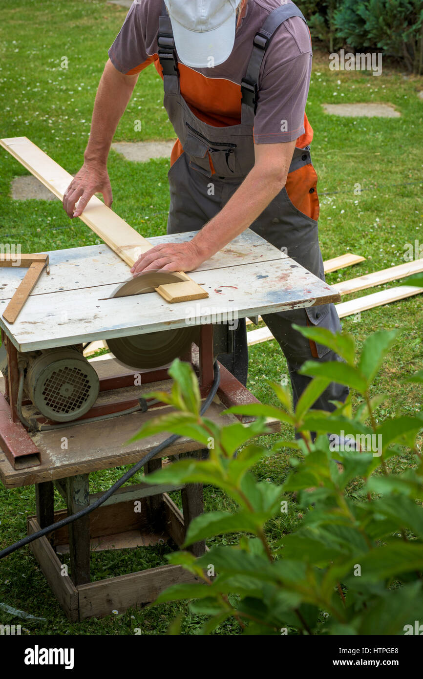 Carpenter working with electric buzz saw cutting wooden boards Stock ...