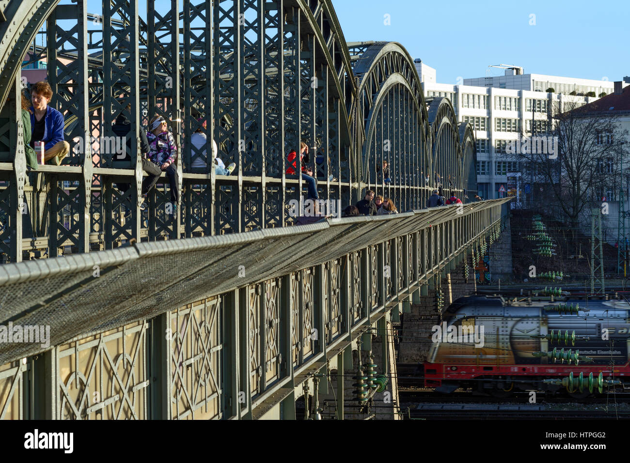 München, Munich, people sitting in the framework of road bridge ...