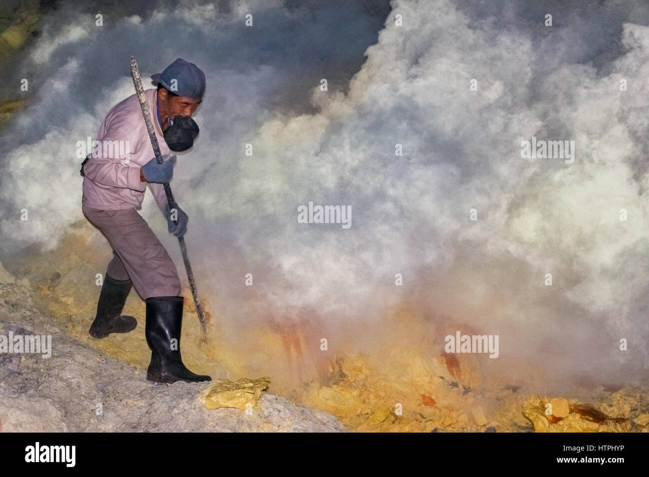 Sulfur miner diggs sulfur at open-pit sulfur mine at bottom of crater ...