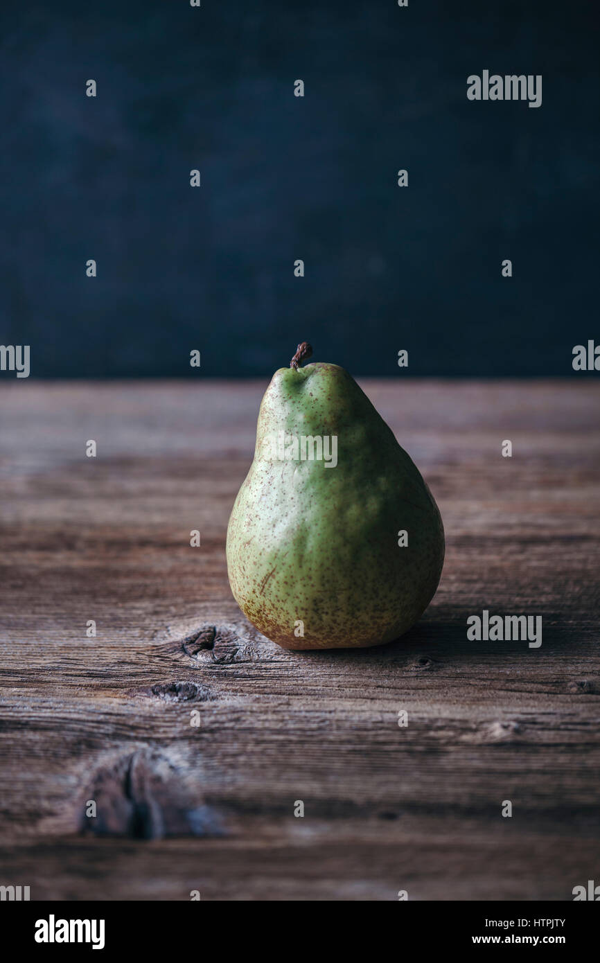 Single pear on a rustic wooden table Stock Photo - Alamy