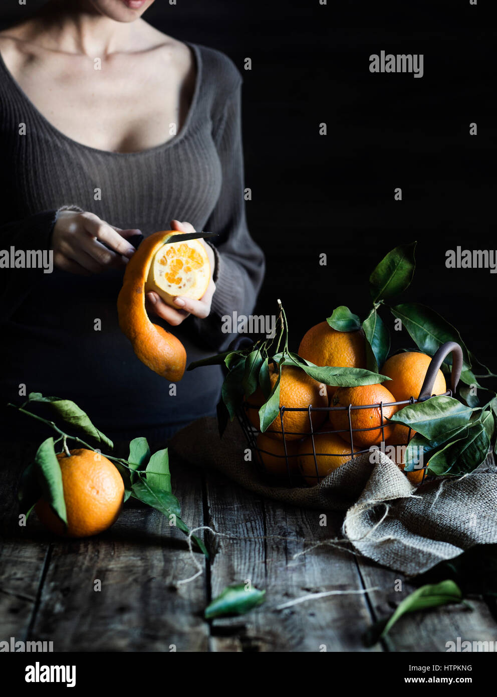 Woman peeling a orange Stock Photo - Alamy