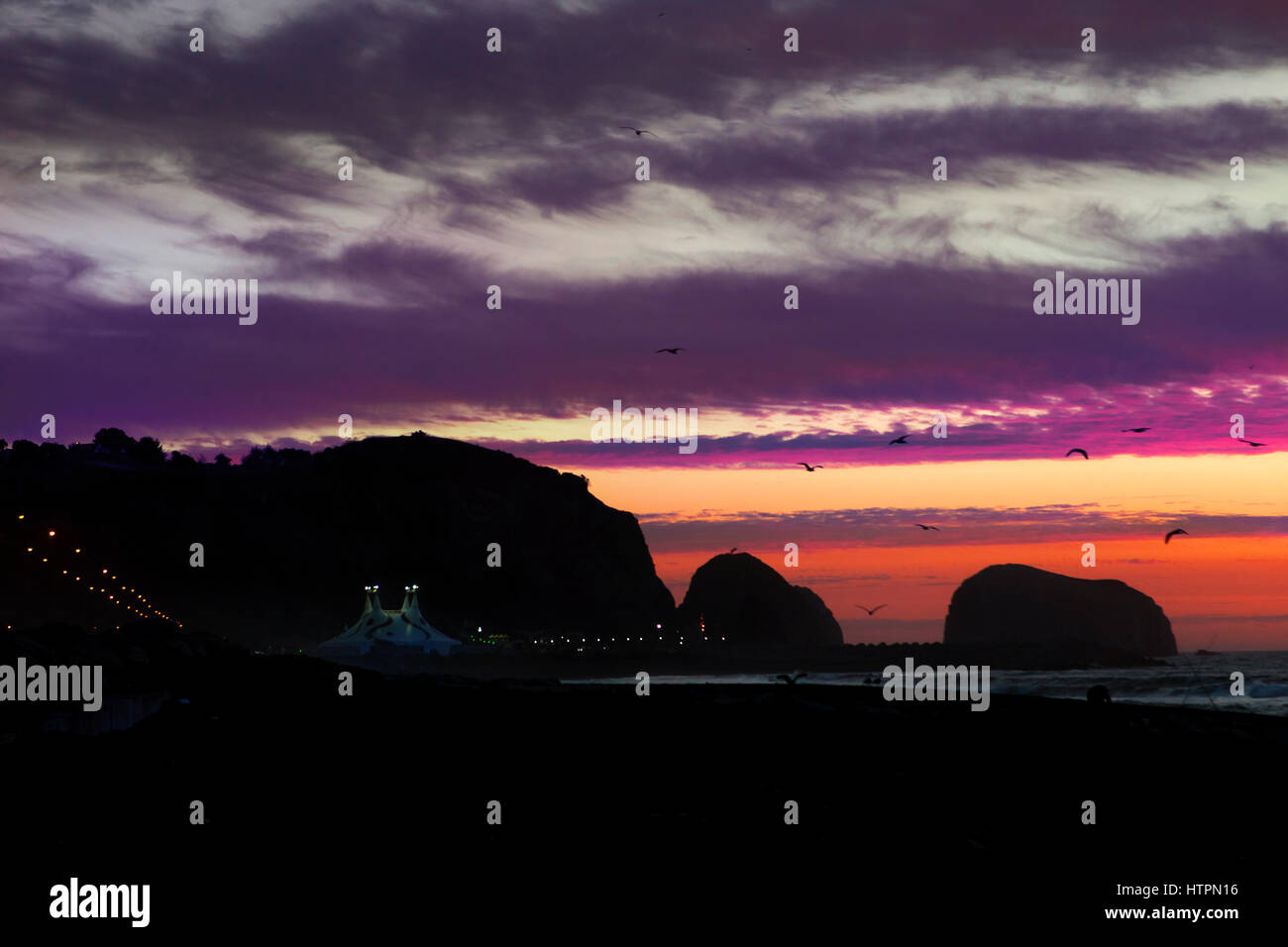 A sunset view of a travel circus in the distance at the sea side of an ...