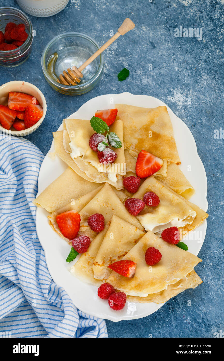Crepes topped with cream,berries, icing sugar Stock Photo - Alamy