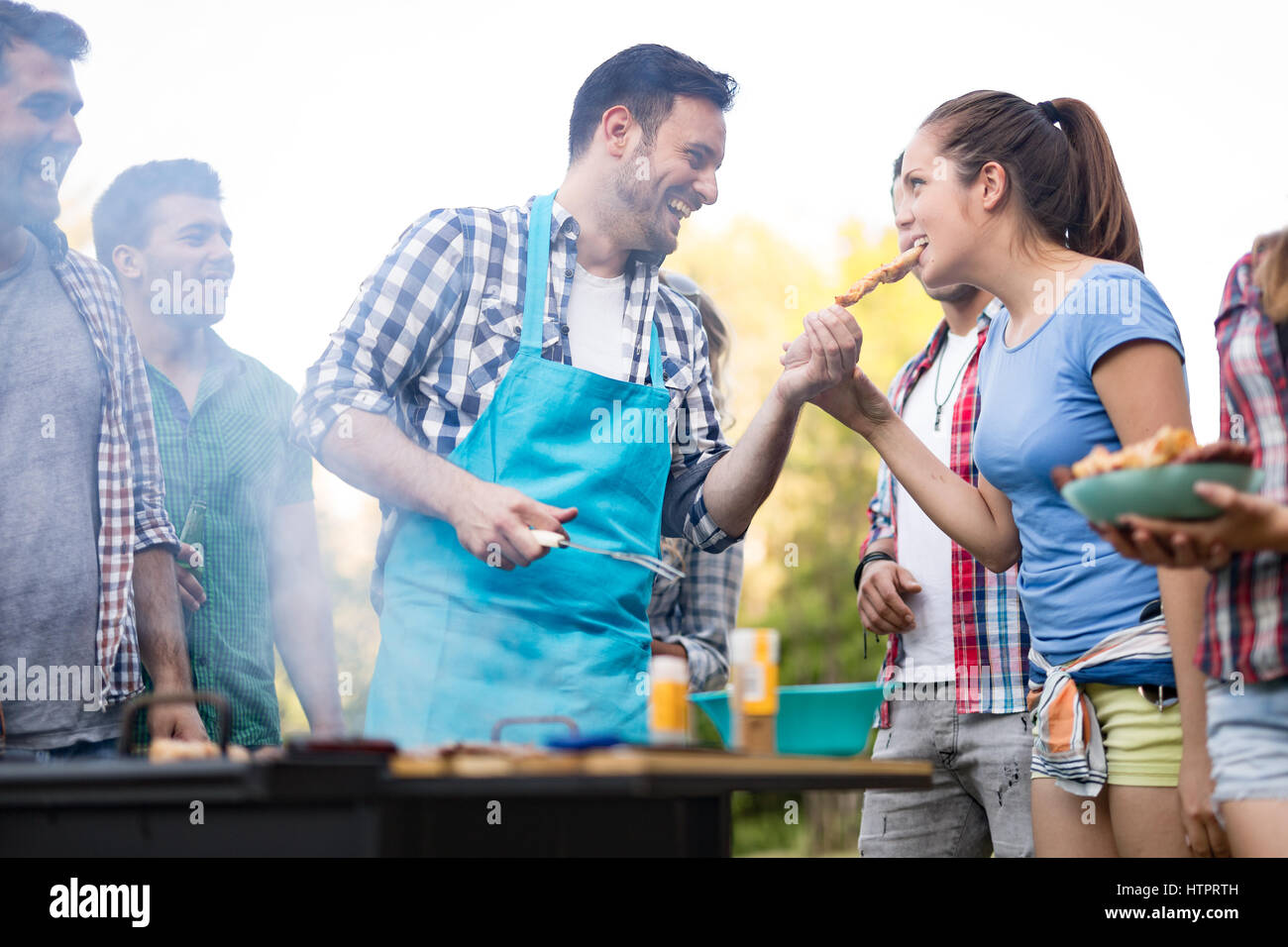 Happy friends grilling meat and enjoying barbecue party outdoors Stock ...
