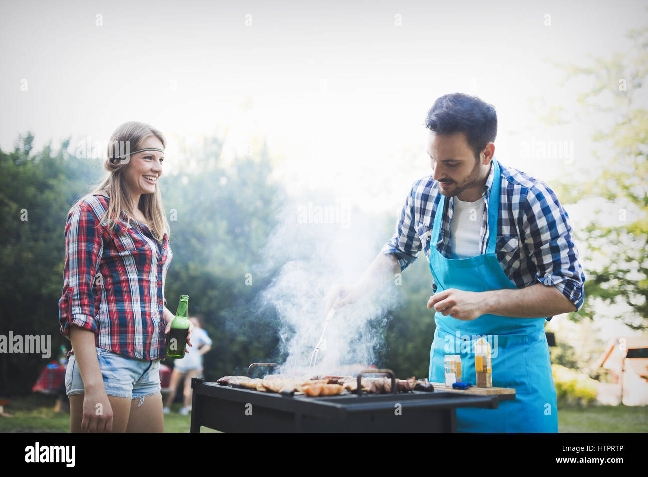Friends having fun grilling meat enjoying bbq party Stock Photo - Alamy