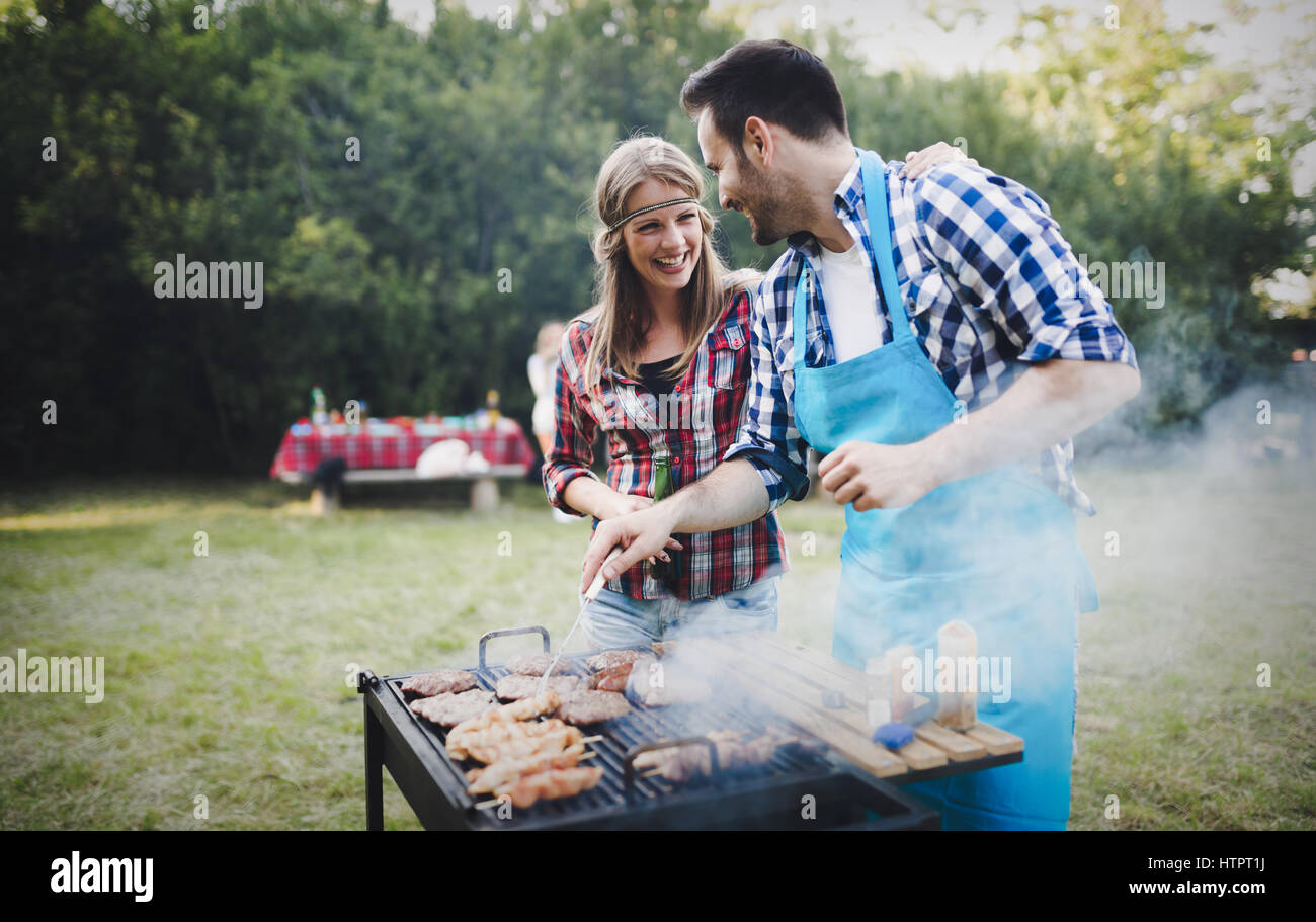 Friends having fun grilling meat enjoying bbq party Stock Photo - Alamy