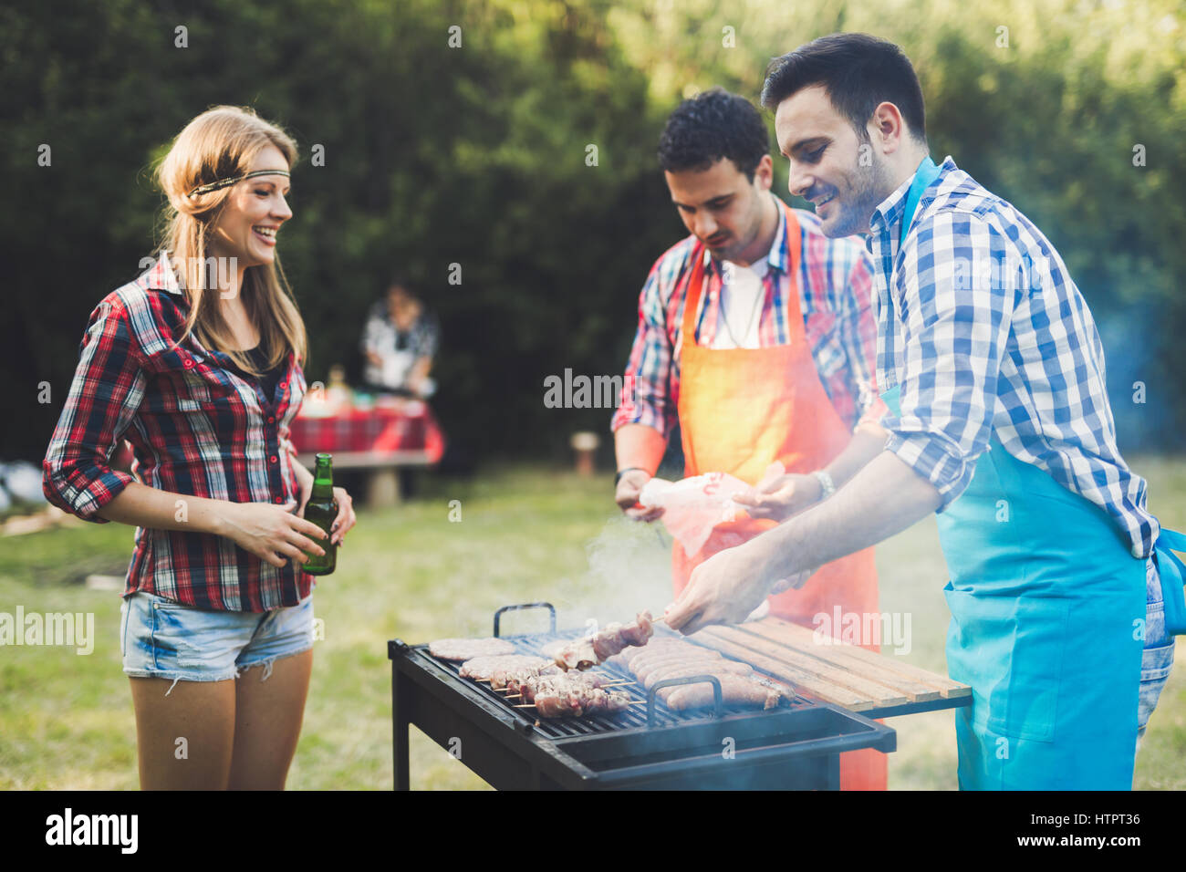 Friends having a barbecue party in nature while having a blast Stock ...