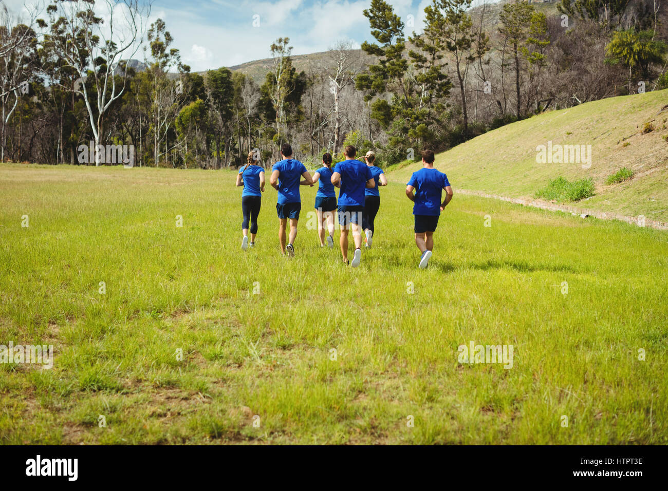 Rear view of fit people running in boot camp Stock Photo - Alamy