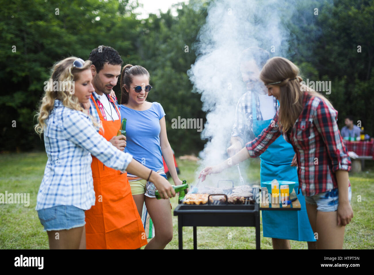 Friends having fun grilling meat enjoying bbq party Stock Photo - Alamy