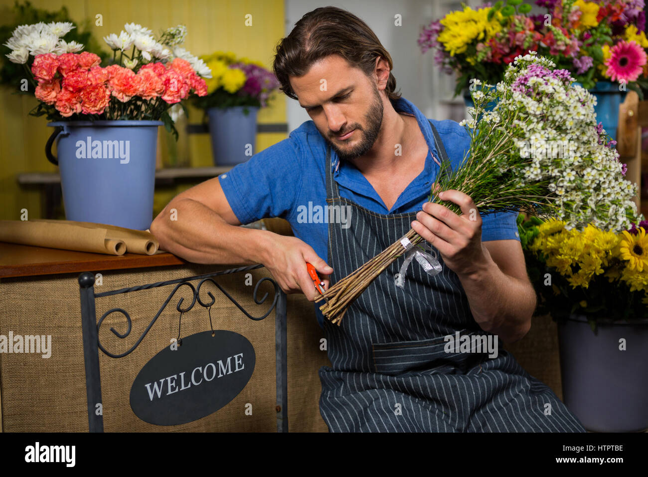 Male florist preparing a flower bouquet in flower shop Stock Photo - Alamy