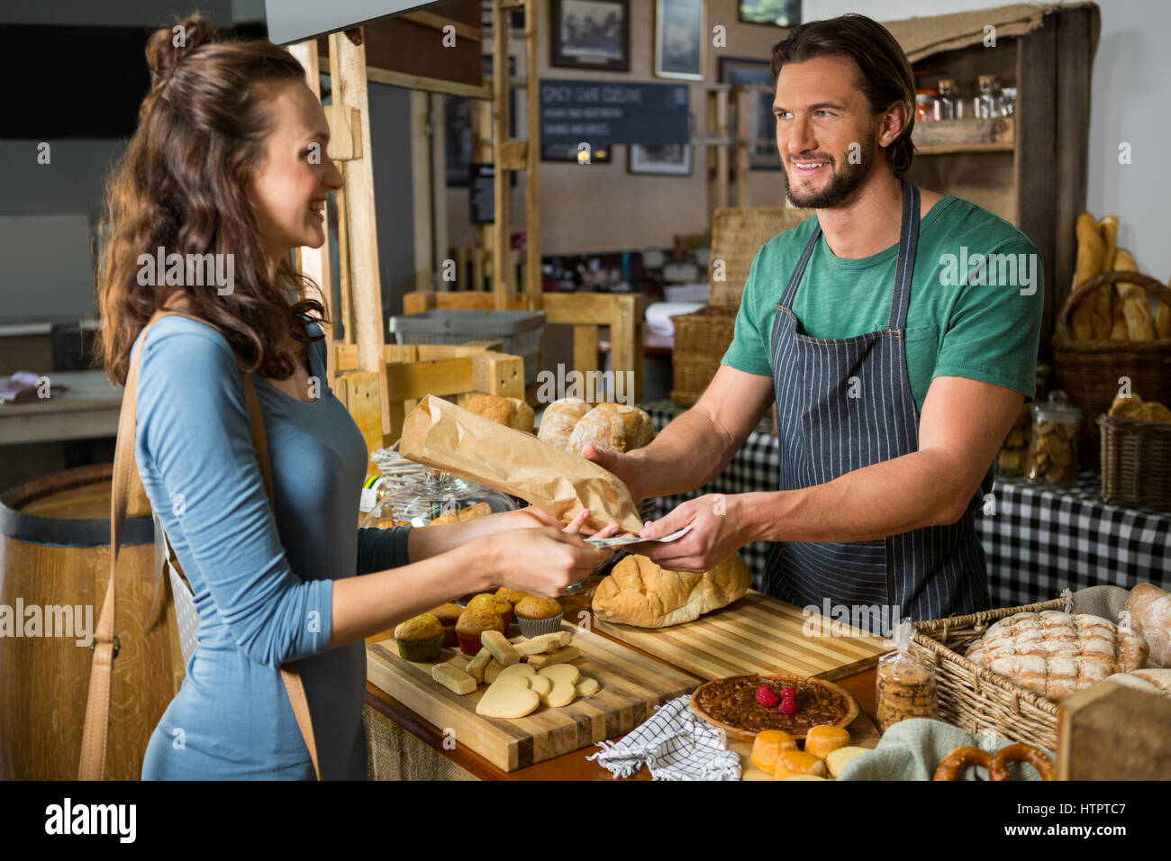 Staff receiving payment from the customer in bakery shop Stock Photo ...