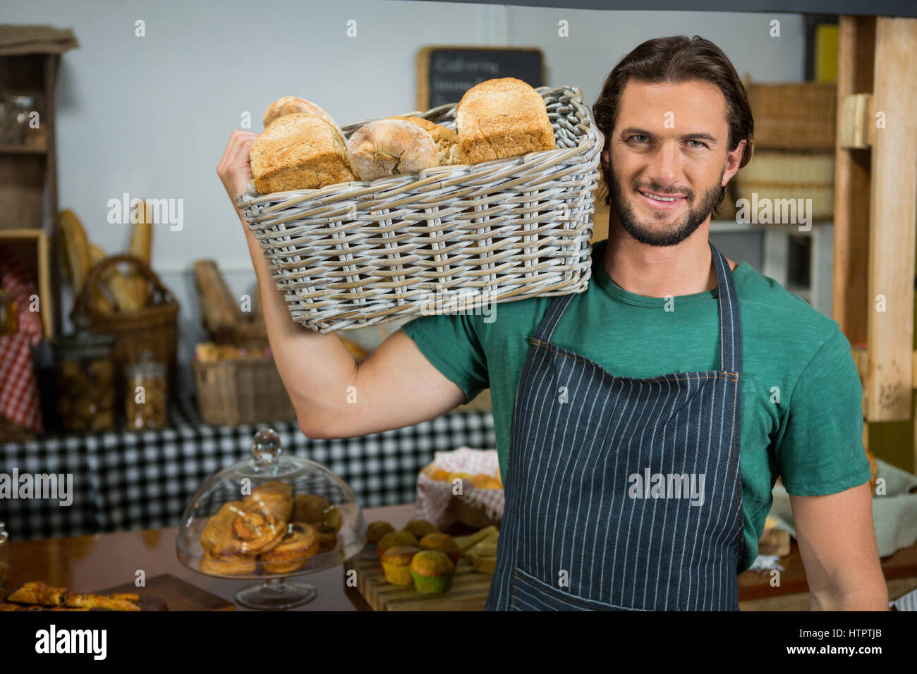 Portrait of male staff holding a basket of bread in bakery shop Stock ...