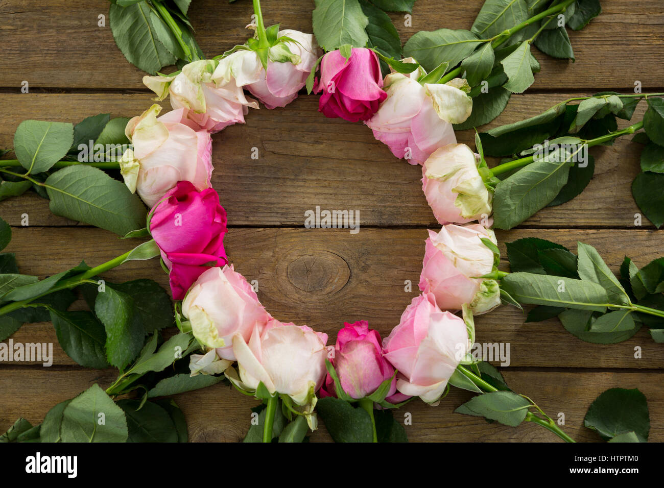 Close-up of pink roses arranged in round shape on wooden plank Stock ...