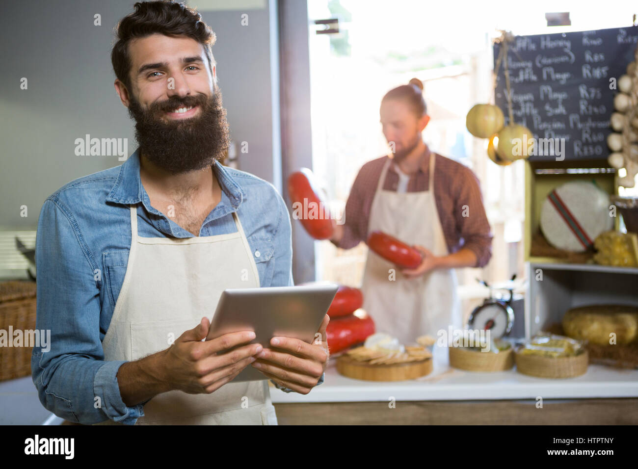 Portrait of smiling staff using digital tablet in market Stock Photo ...
