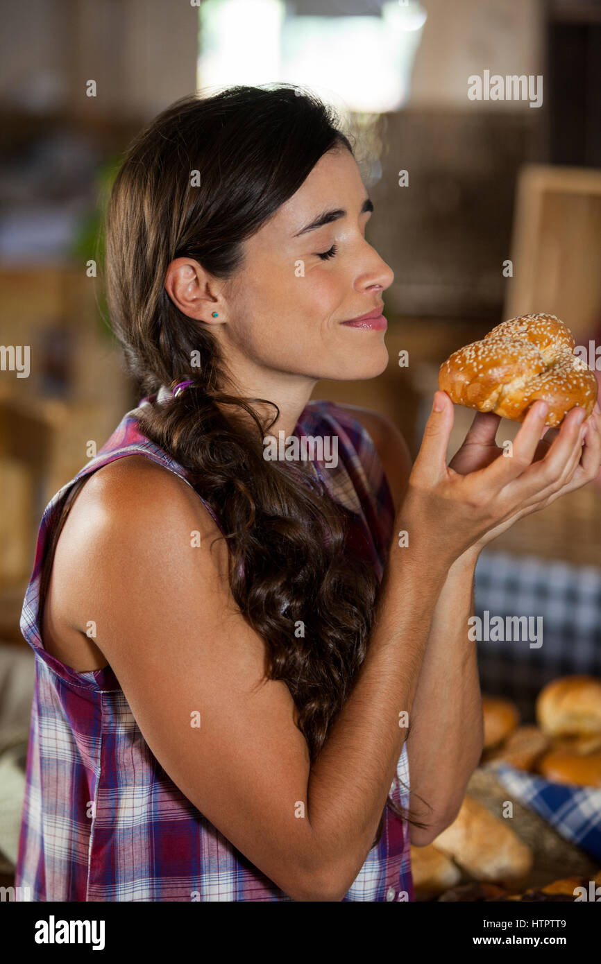Smiling woman smelling a bread at counter in market Stock Photo - Alamy