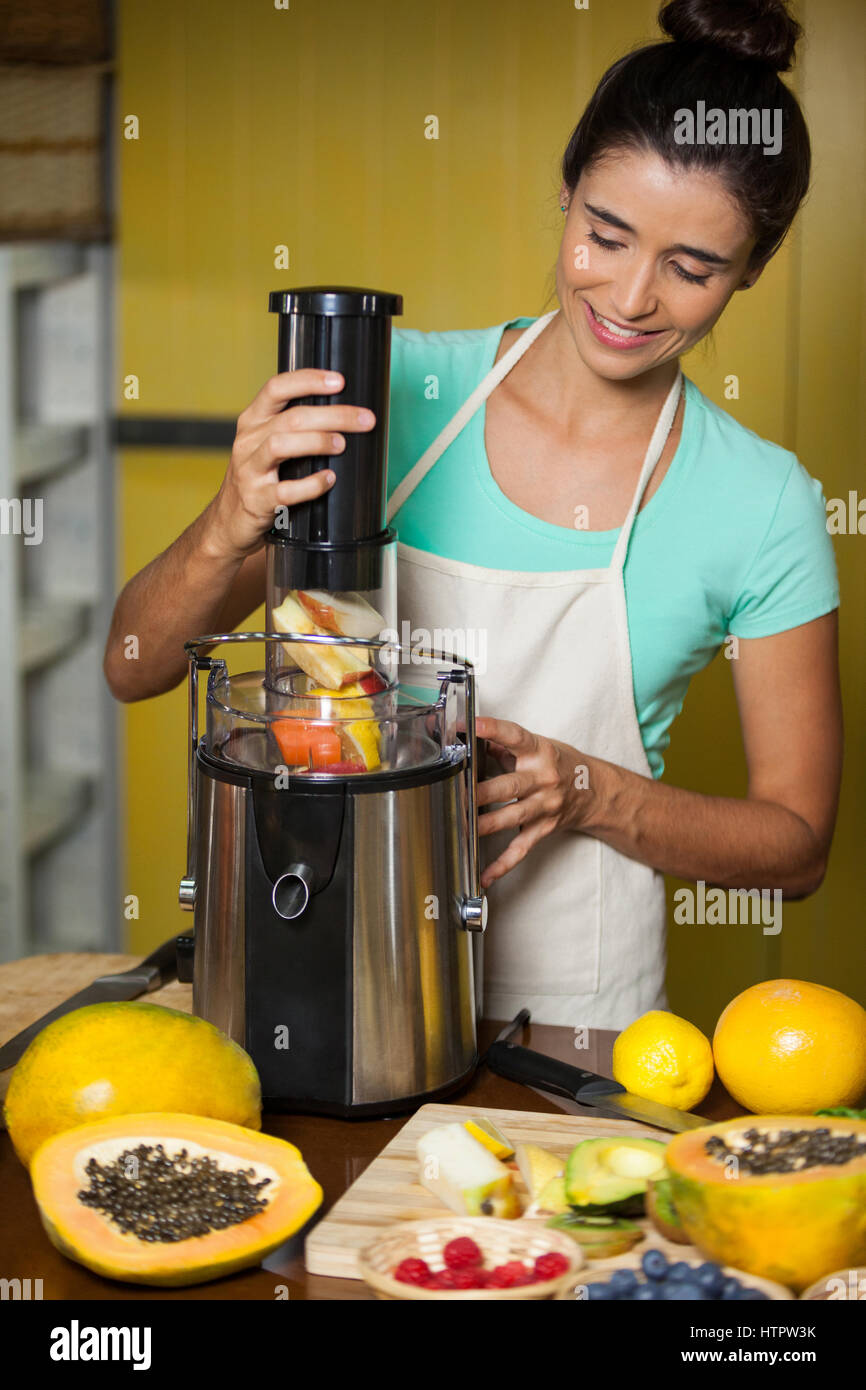 Smiling shop assistant preparing juice at health grocery shop Stock ...