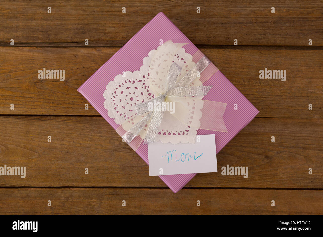 Top view of gift box with mom text on card against wooden background ...