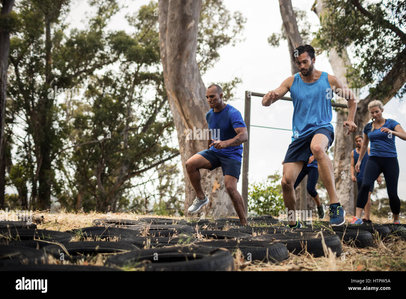 People receiving tire obstacle course training in boot camp Stock Photo ...
