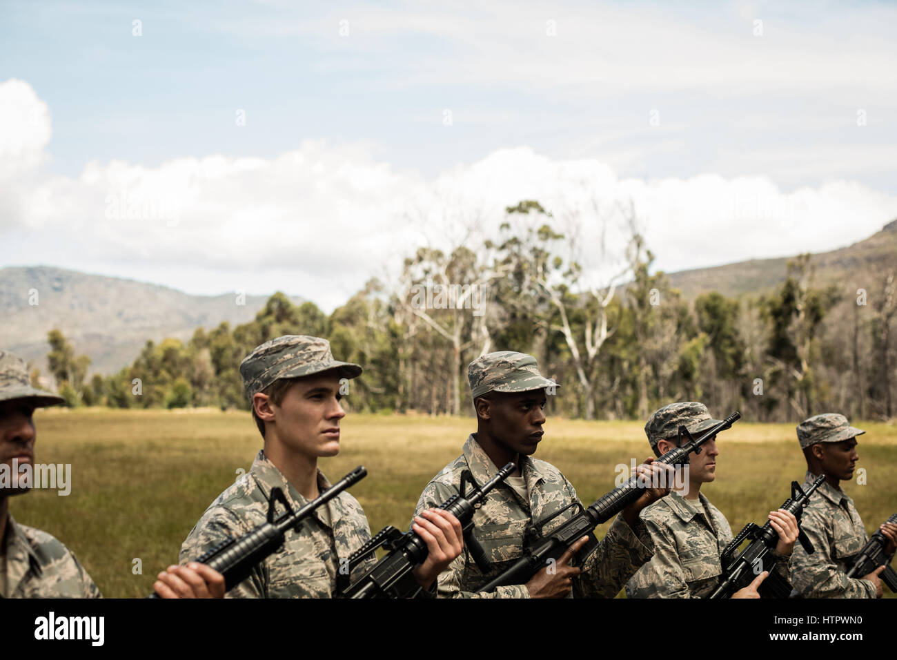 Group of military soldiers standing with rifles at boot camp Stock ...