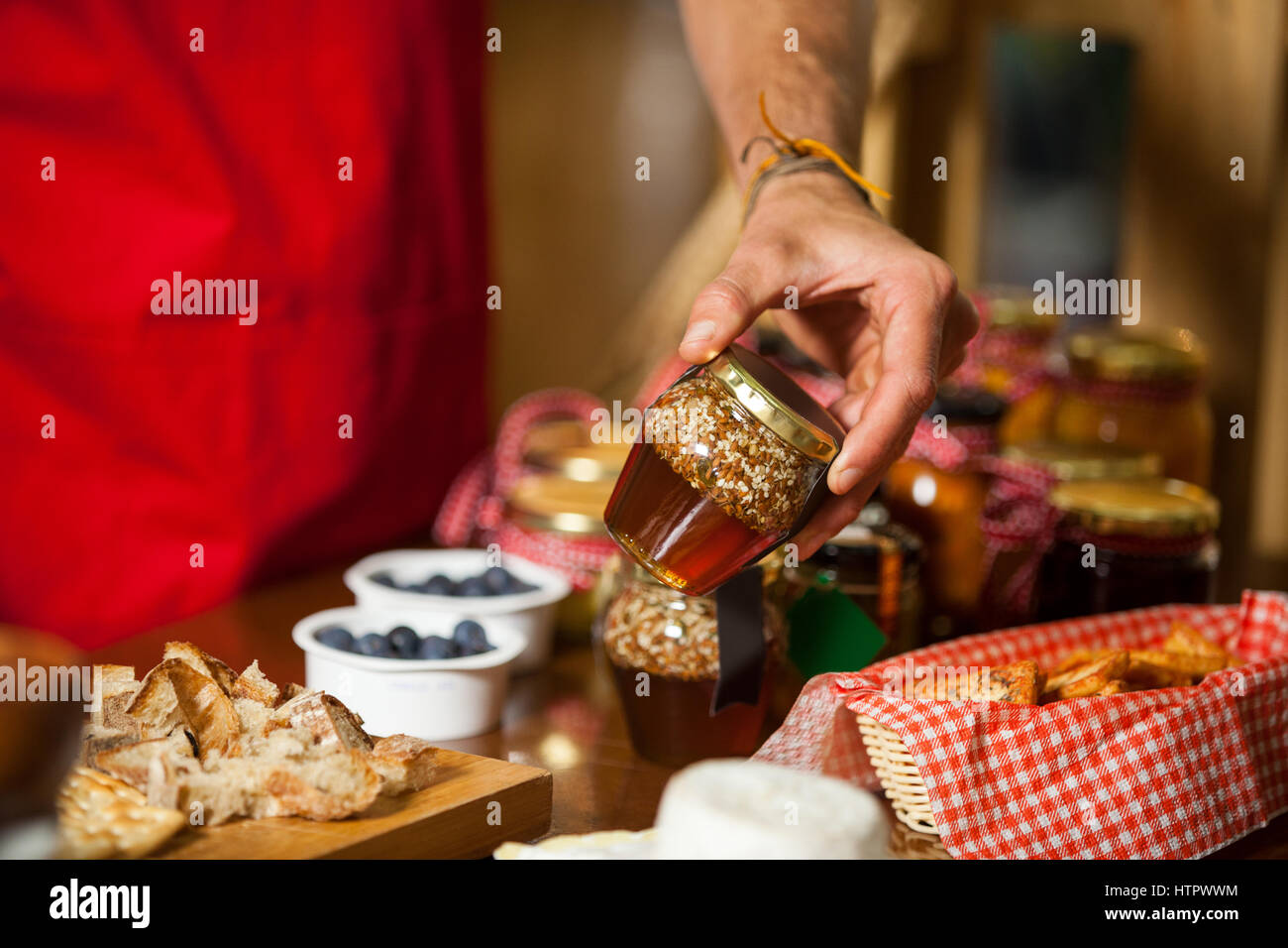 Mid-section of staff checking pickle jar at counter in market Stock ...