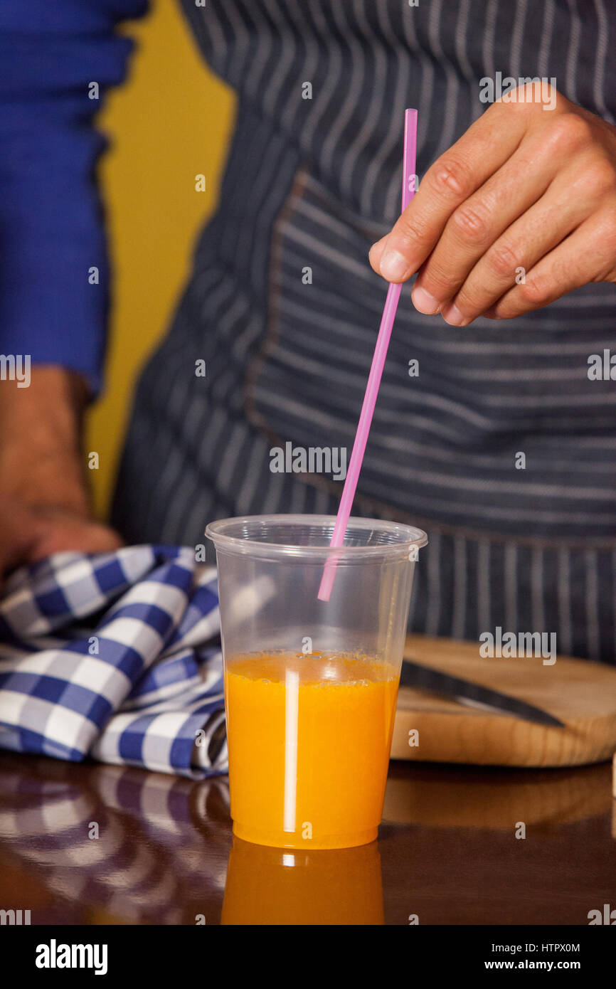 Male staff putting straw in a glass at supermarket Stock Photo - Alamy