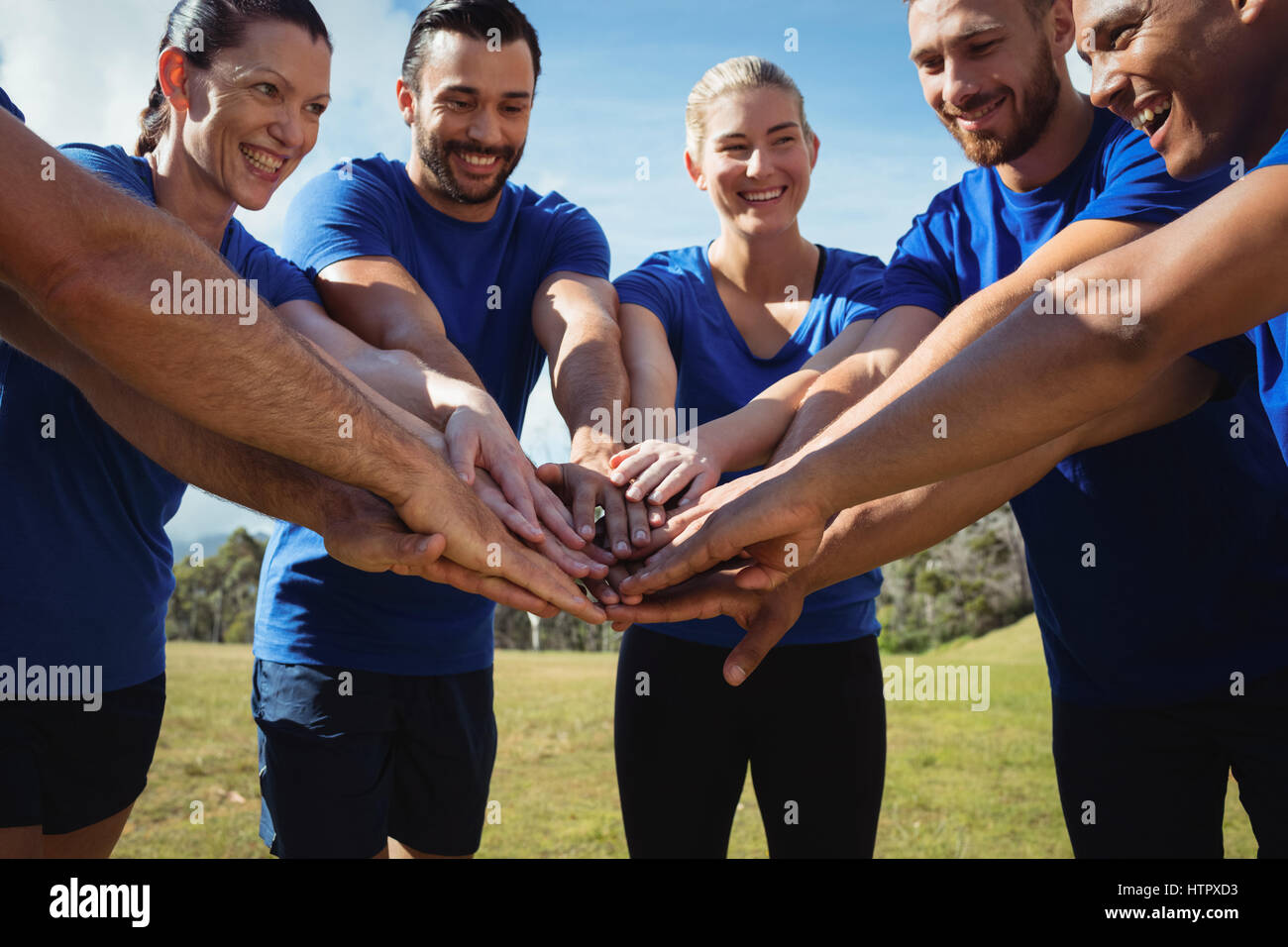 Group of people stacking their hands together in boot camp Stock Photo ...