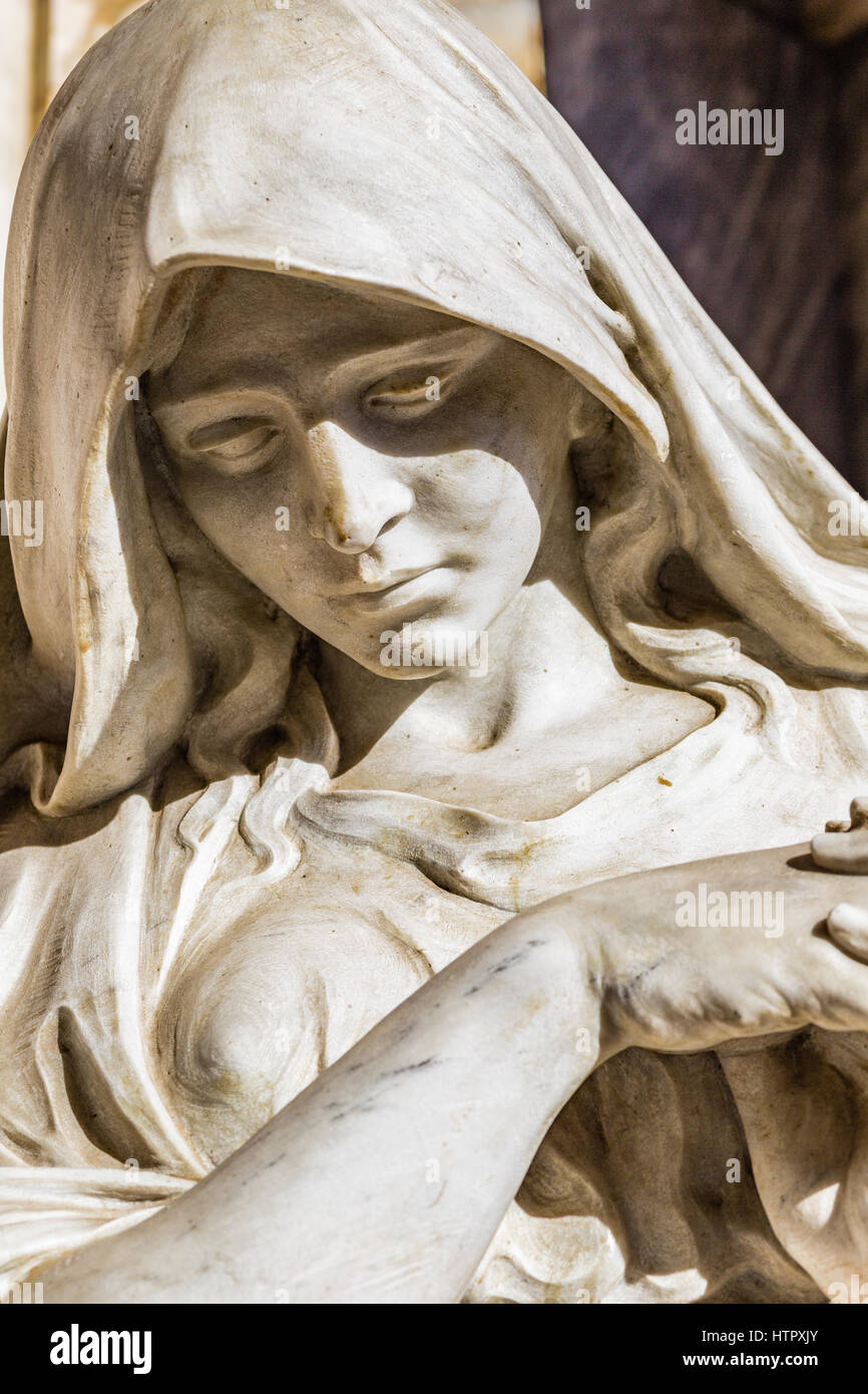 statue of sad woman looking down with reclined head and hands together ...