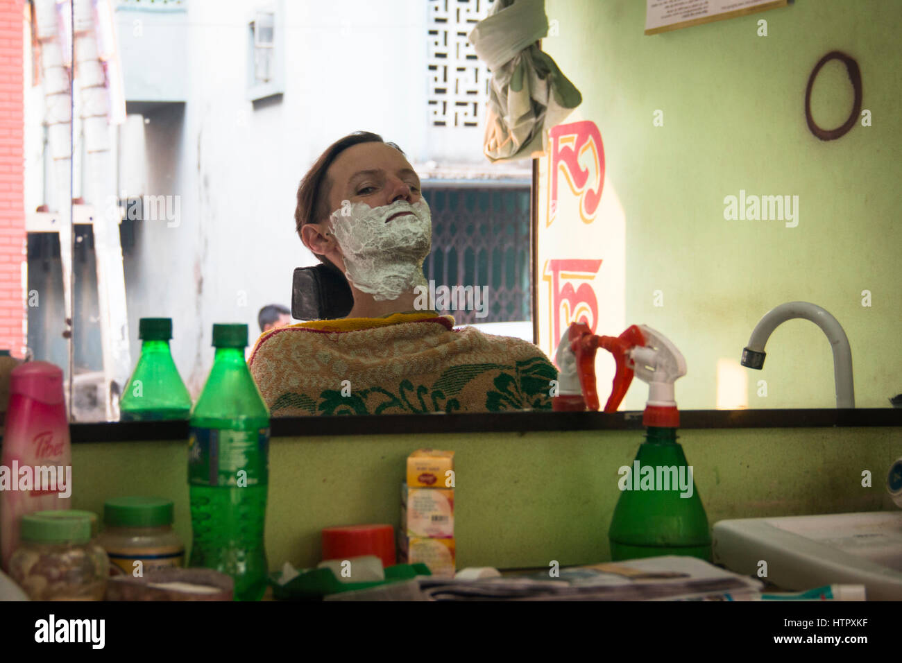 KHULNA, BANGLADESH - FEBRUARY 2017: Tourist being shaved in a ...