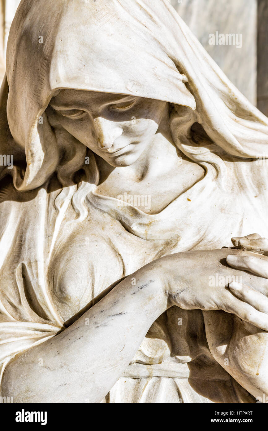 statue of sad woman looking down with reclined head and hands together ...
