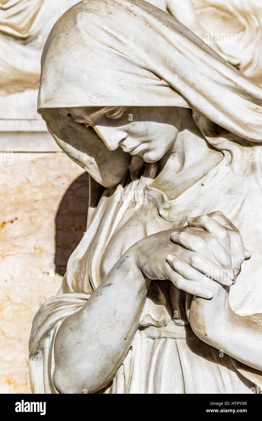 statue of sad woman looking down with reclined head and hands together ...
