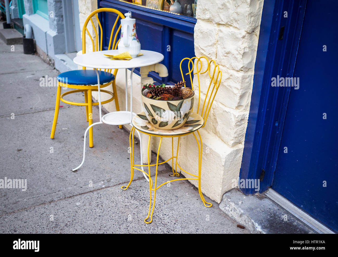 Cafe patio showing two chairs with a teapot on a beautiful day. The ...