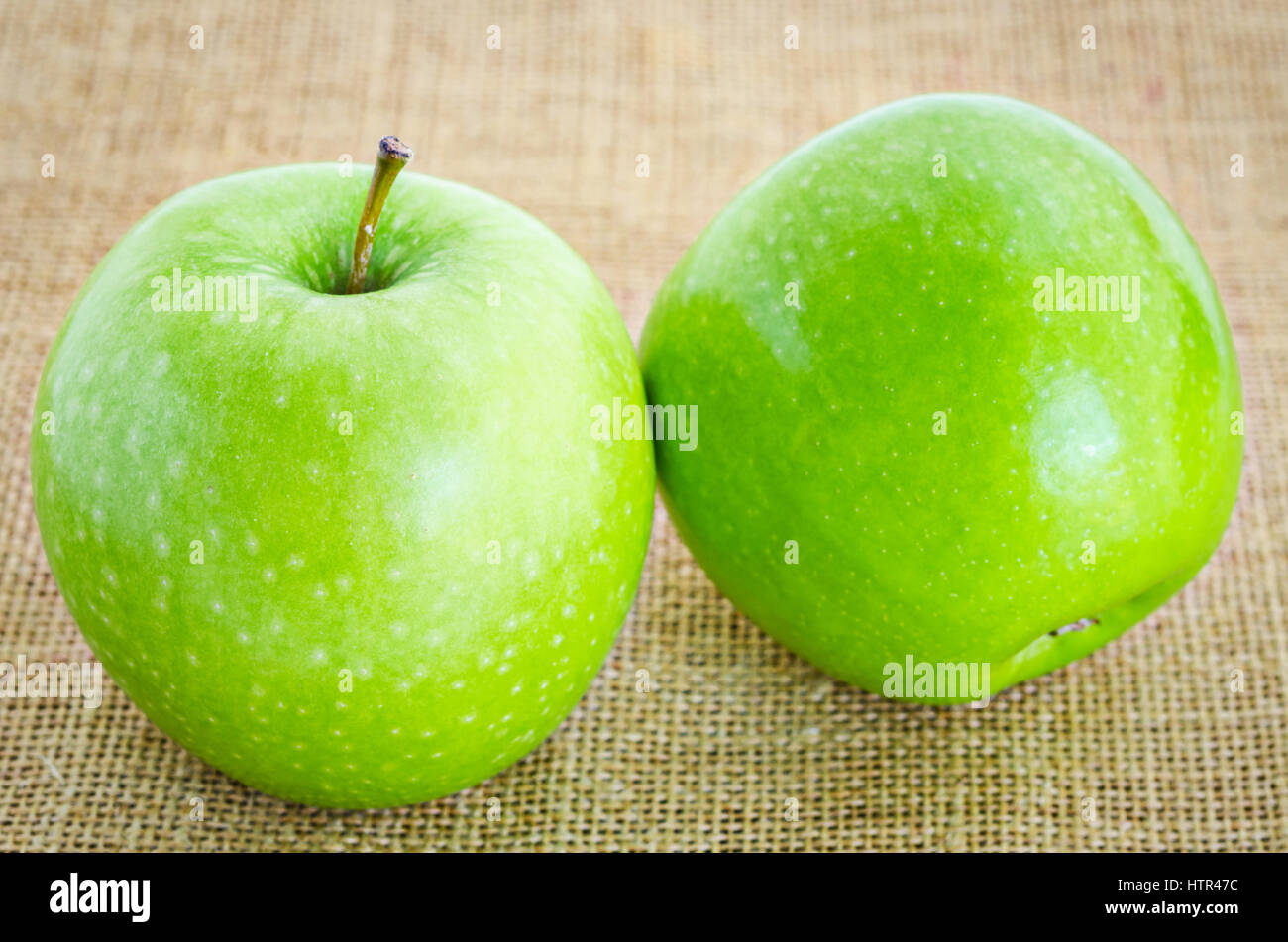 Ripe green apples on sack background Stock Photo - Alamy
