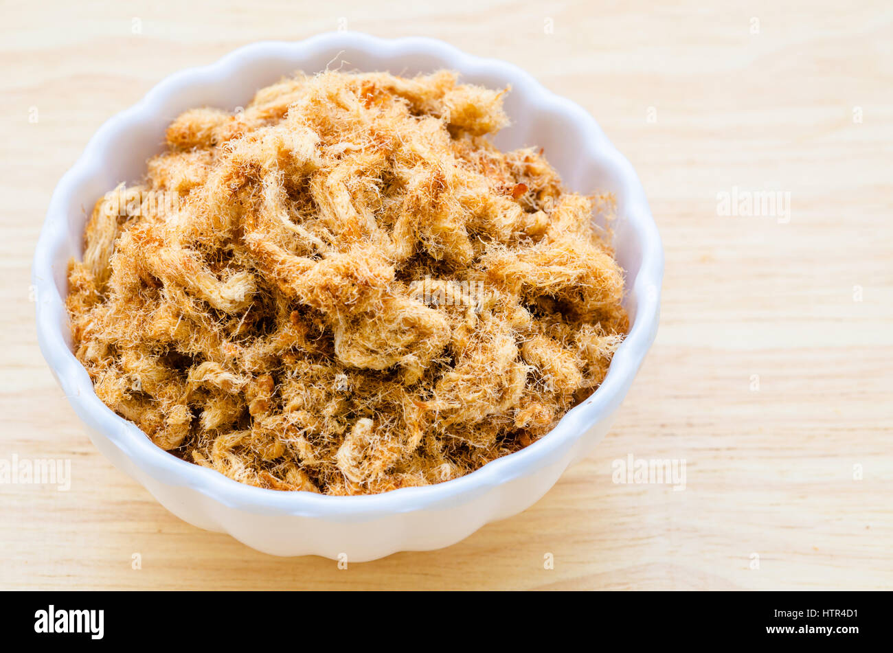Dried shredded pork chinese food in white cup on wooden background ...