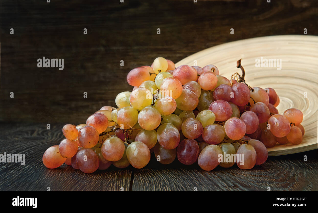 grapes ripe on a wooden plate Stock Photo - Alamy