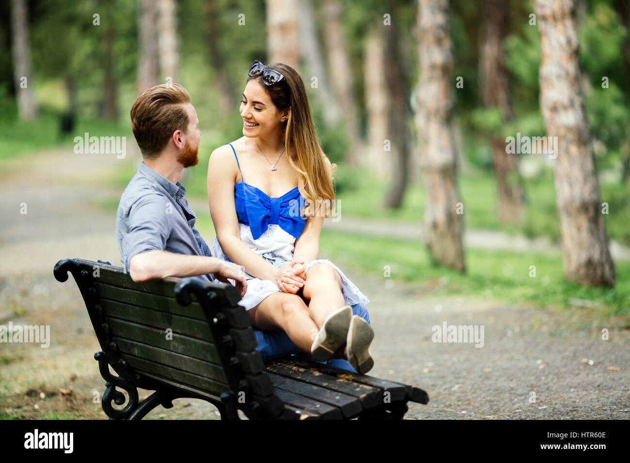 Romantic couple in love sitting on park bench Stock Photo - Alamy