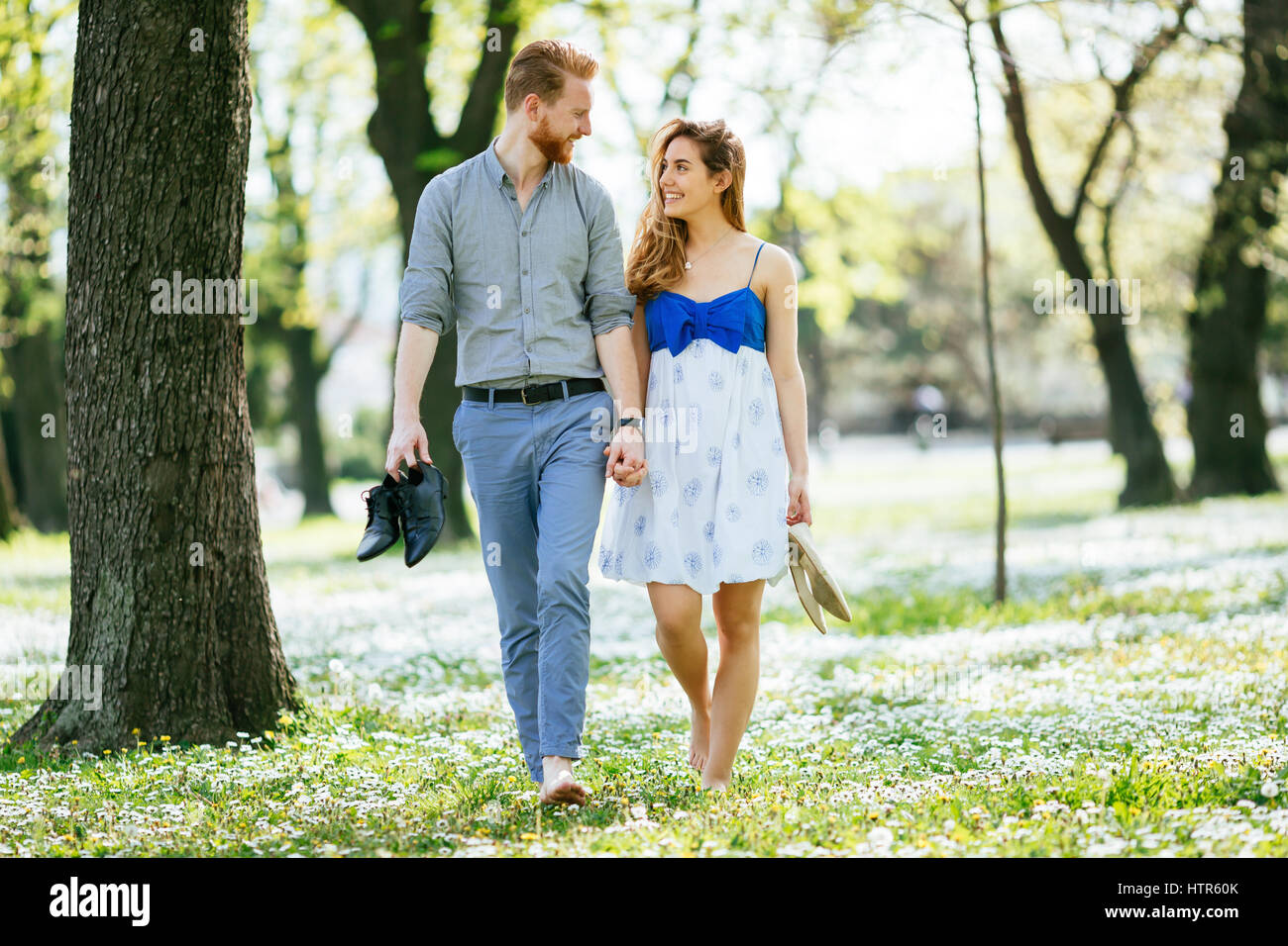 Couple enjoying romantic walk in nature barefoot Stock Photo - Alamy